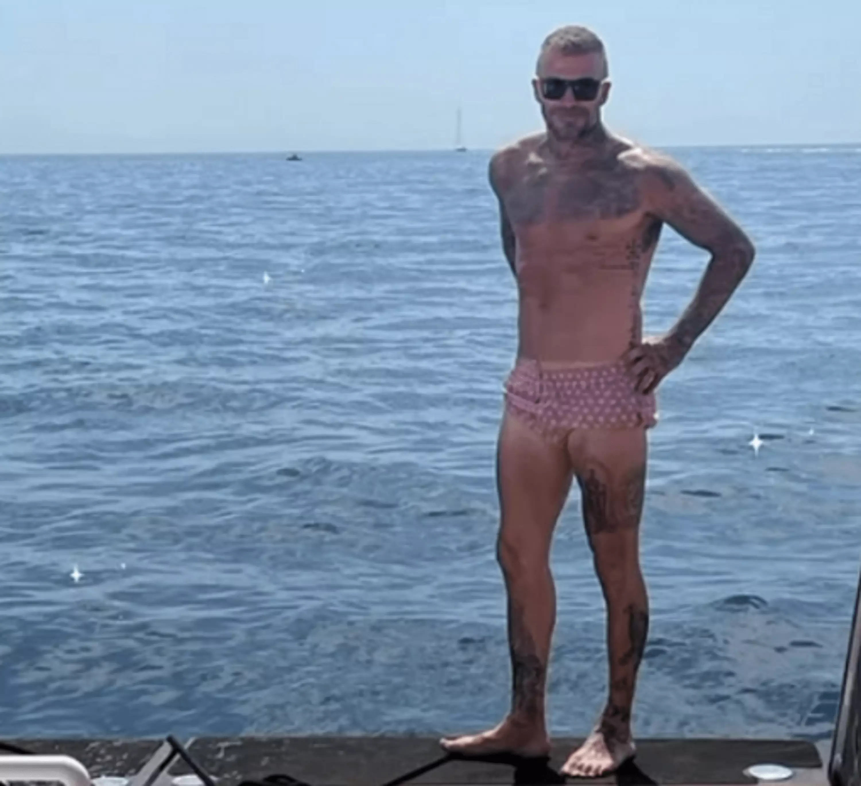 Mens han er på yachtferie med sin familie, praler David Beckham med sine muskler og tatoveringer i en lyserød faldskærmsbikini